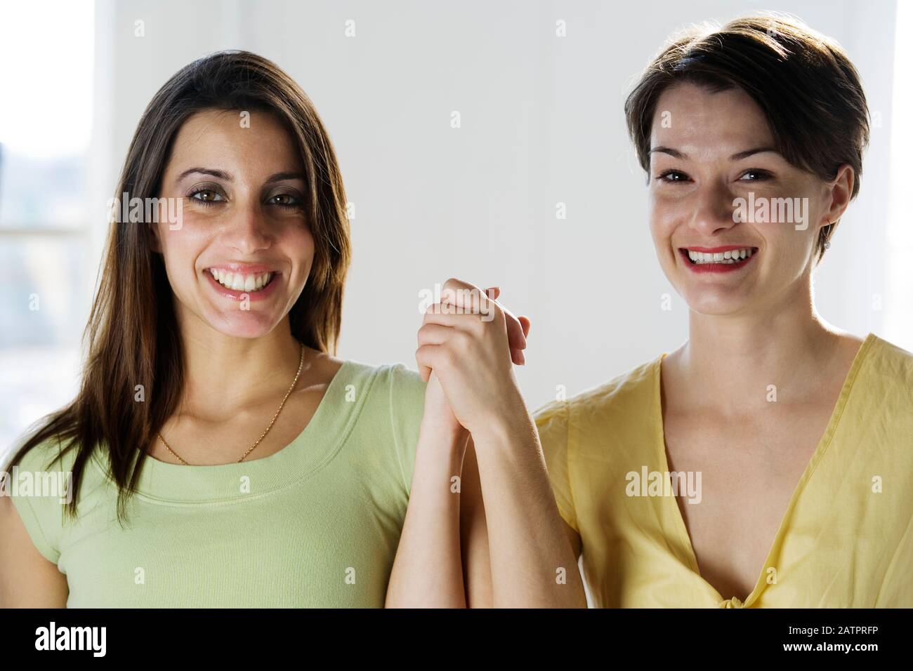 Portrait of two friends smiling and holding hands Stock Photo - Alamy