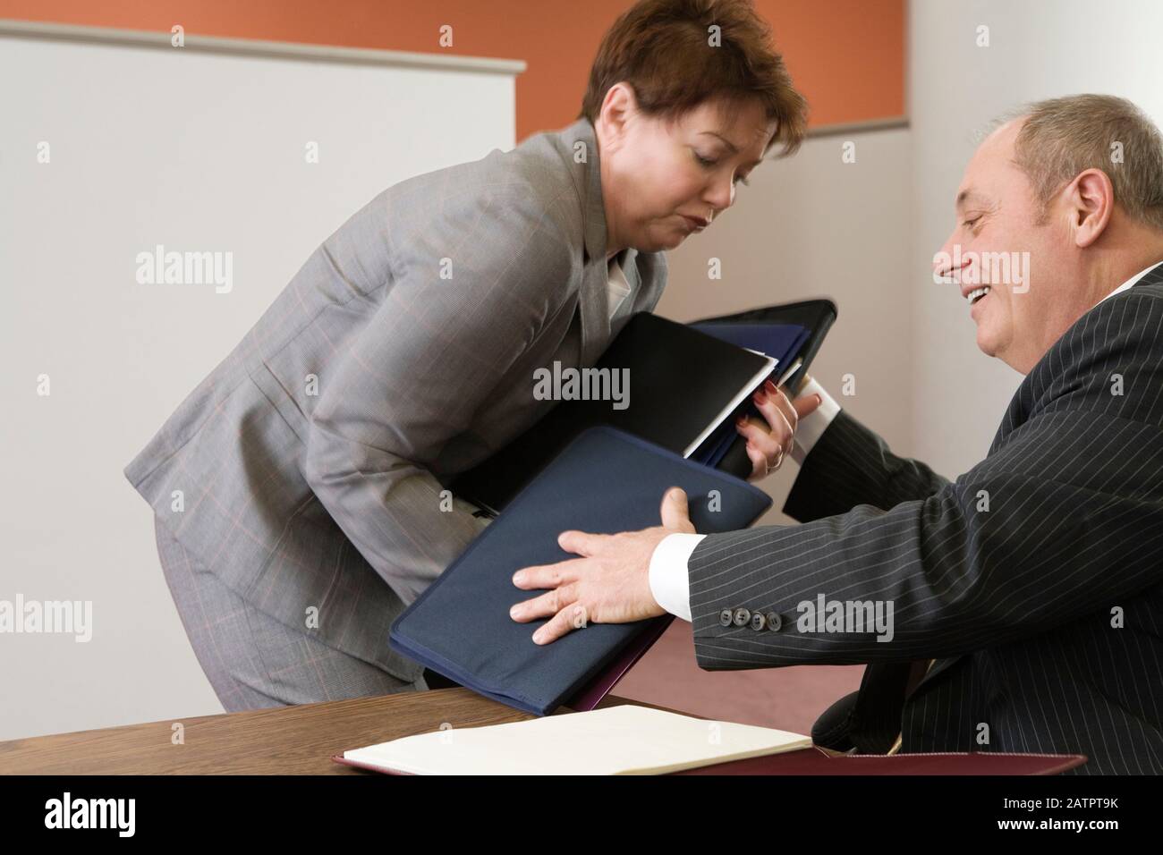 View of business man helping business woman hold files Stock Photo - Alamy