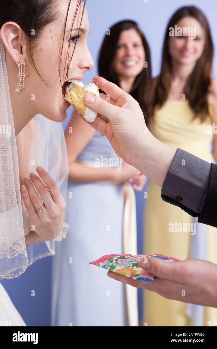 Side view of a bride eating cake Stock Photo - Alamy