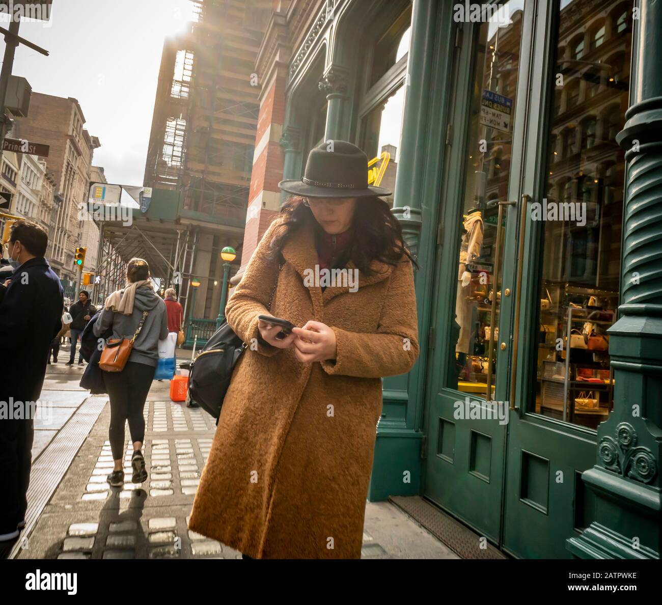 Distracted woman on her smartphone in Soho in New York on Sunday ...