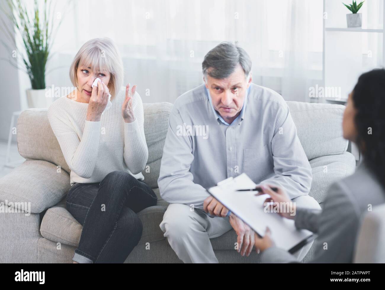 Sad husband and wife talking to psychotherapist Stock Photo - Alamy
