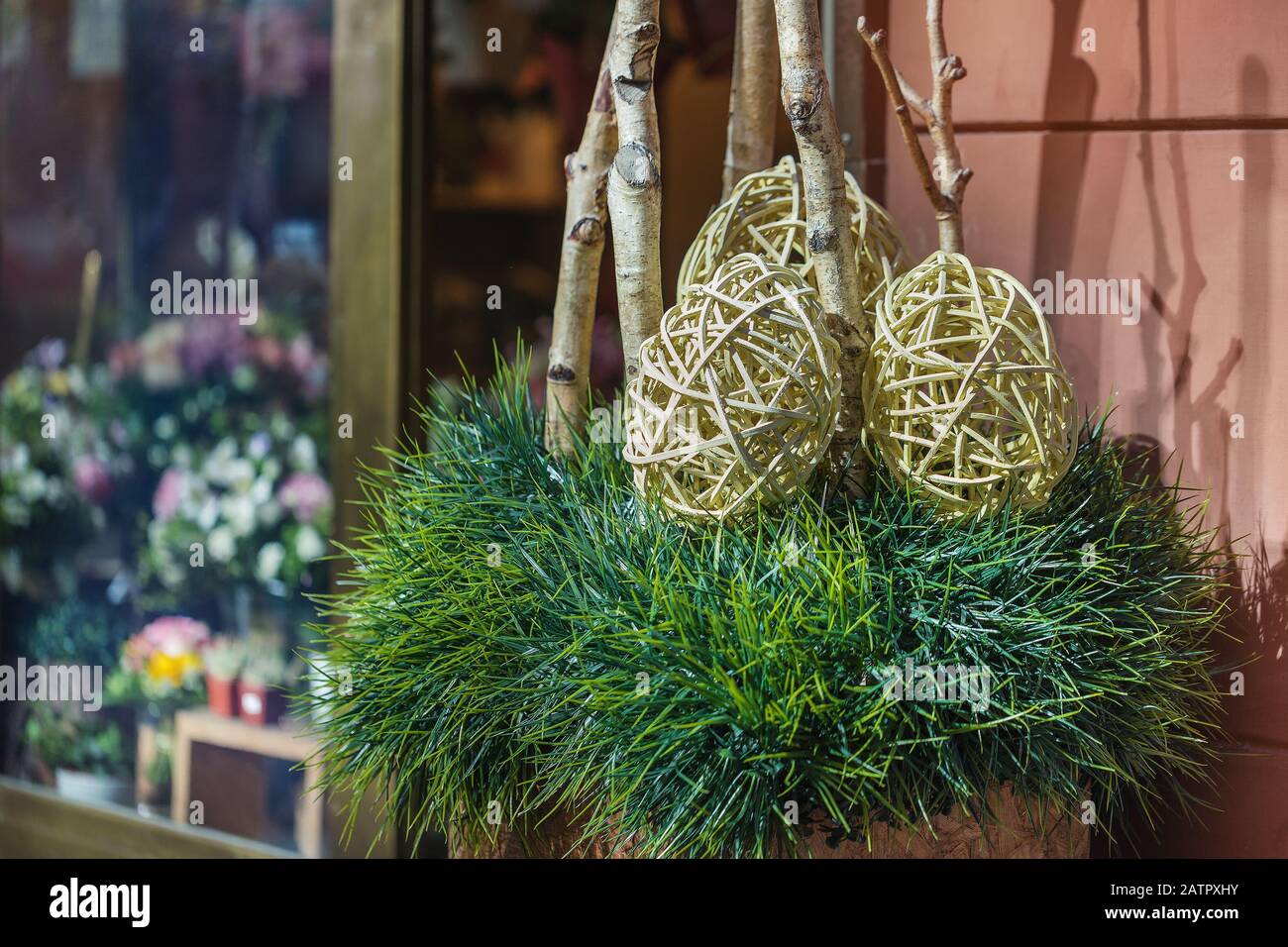 Easter eggs on grass decorations on the street in front of the flower ...