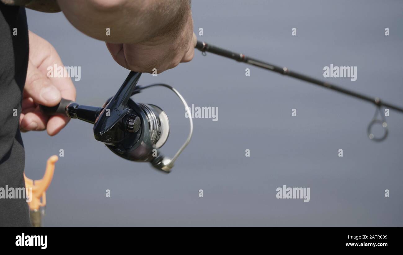 Male hand holding fishing rod and reeling the other hand Stock Photo ...