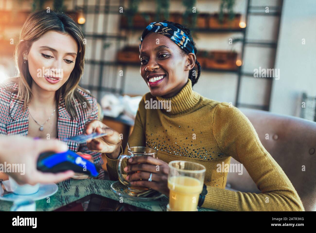 Happy friends using credit card and making contactless payment in a ...