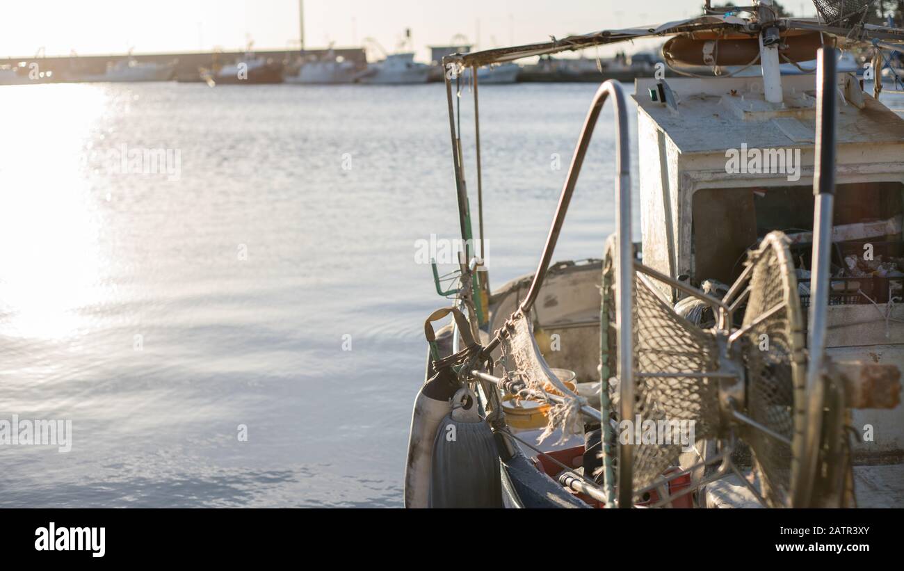 A moored fishing boat is waiting to set sail water while the sun ...
