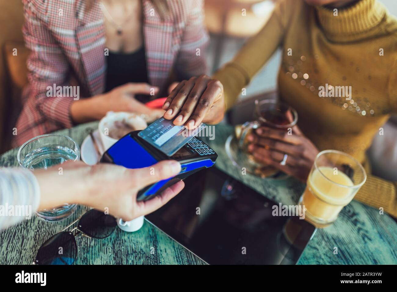 Happy friends using credit card and making contactless payment in a ...
