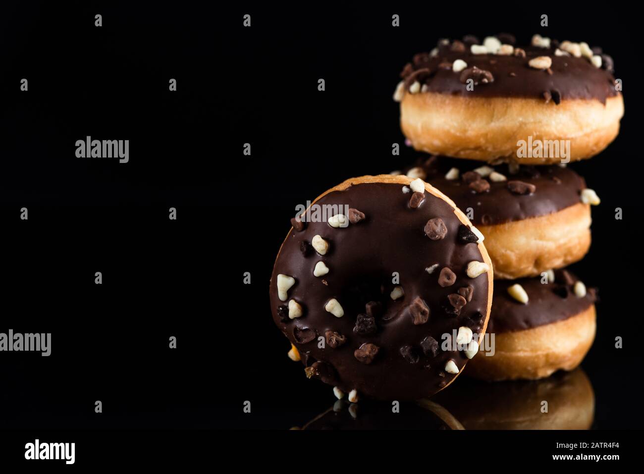 Stack of Chocolate Donuts or Doughnuts on Black Background with Copy ...