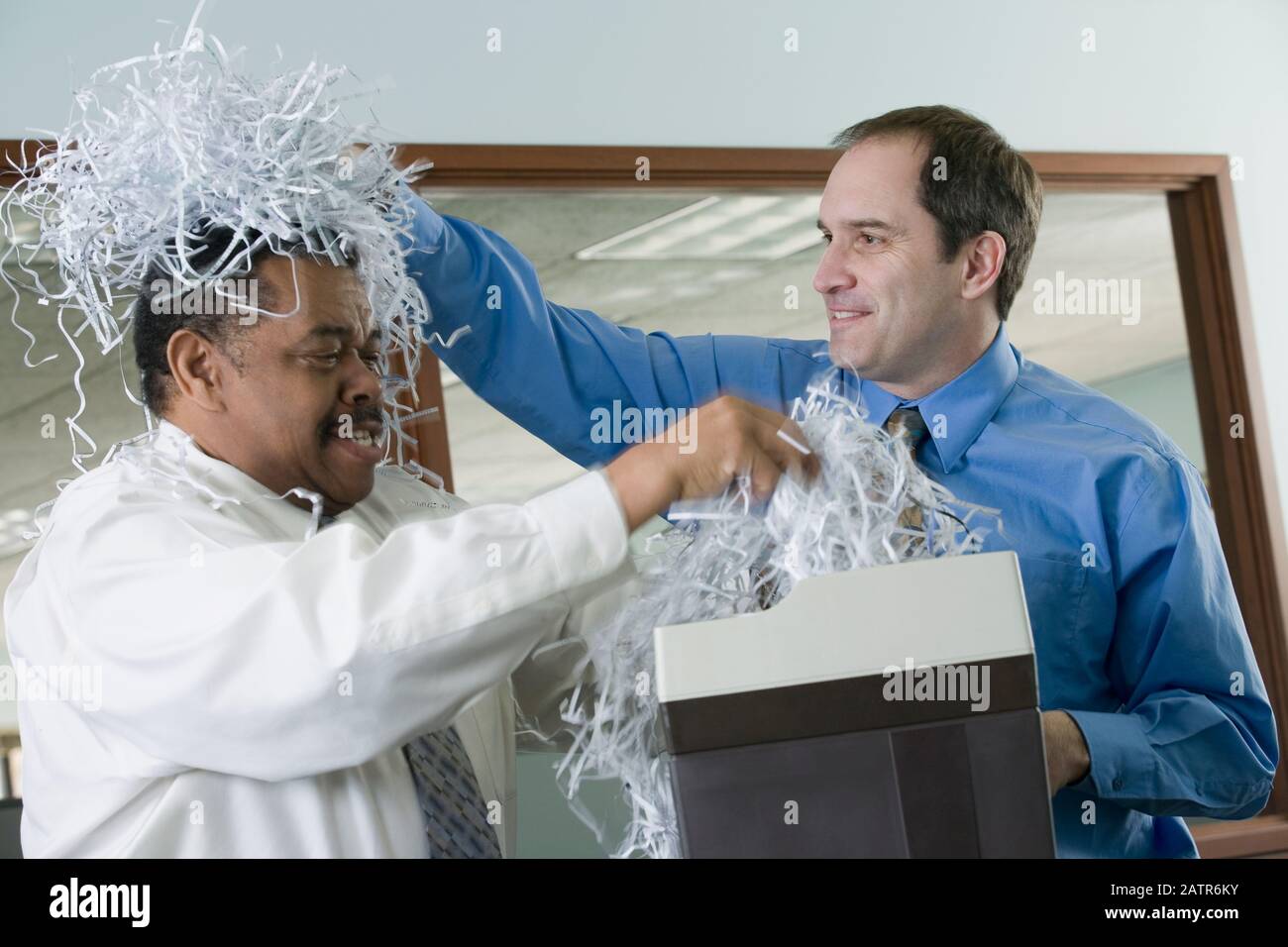 Businessmen playing with shredded paper in the office Stock Photo - Alamy
