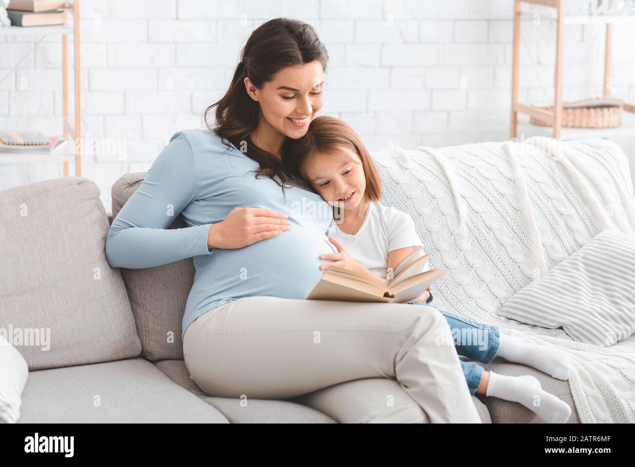 Happy family spending time together at home, reading book Stock Photo ...