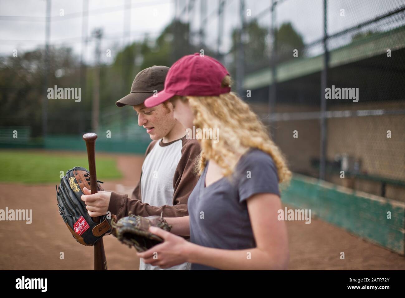 Friends standing on baseball field holding sport equipment Stock Photo ...