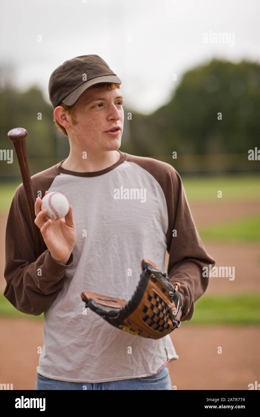 Man holding baseball bat and throwing softball into mitt Stock Photo ...