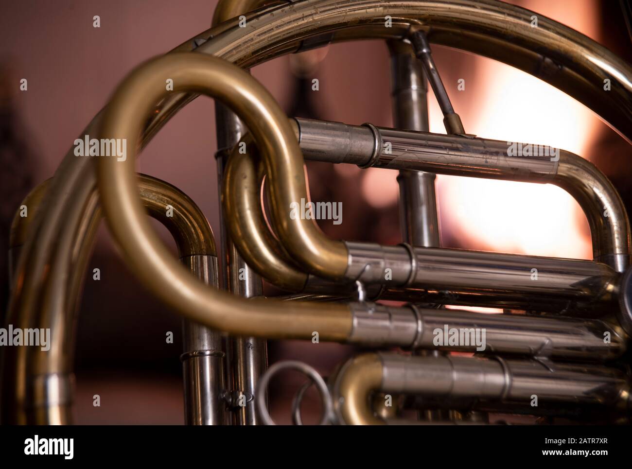 Detail of a valve slide on a French horn with looping brass tubing and ...