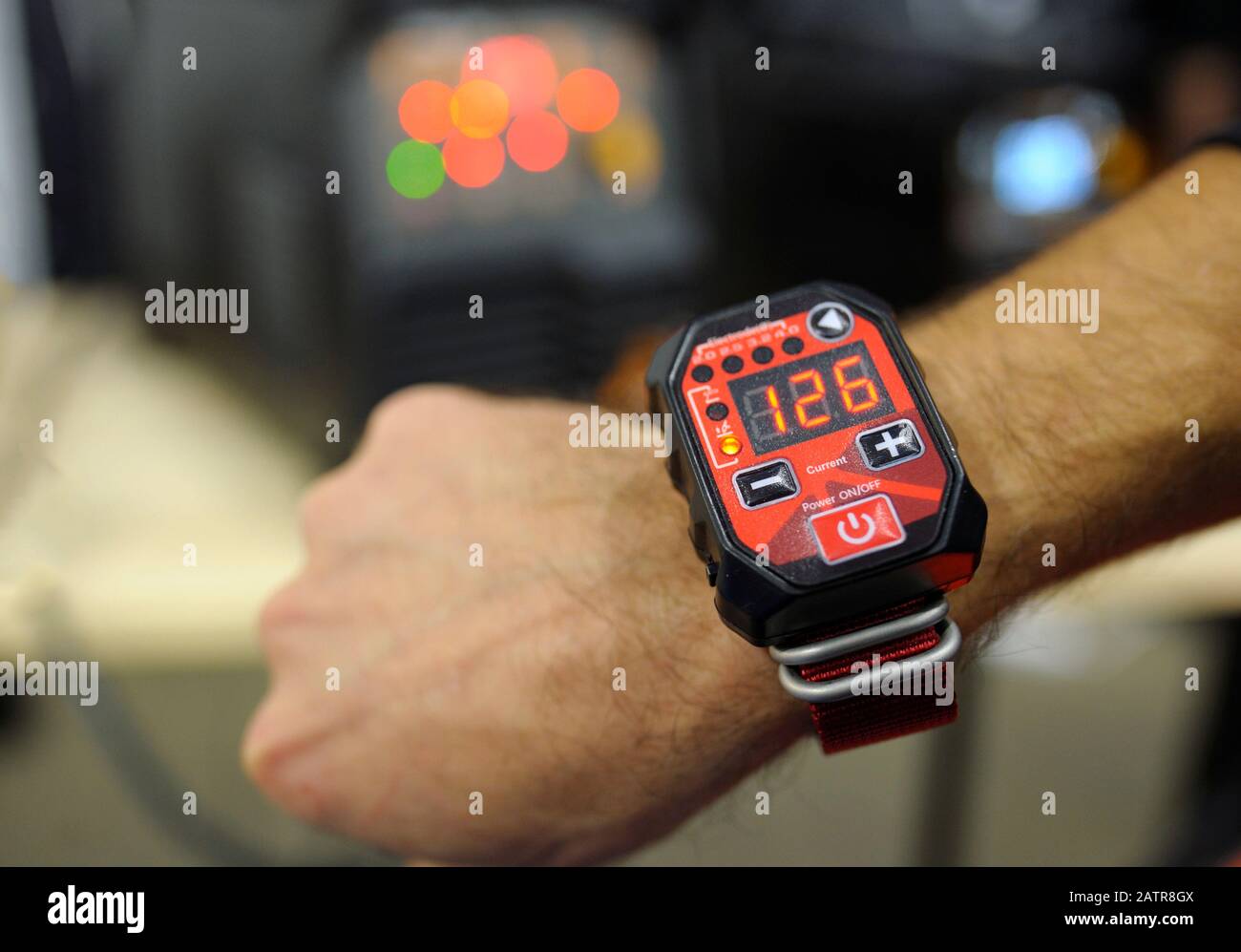 Worker’s hand with remote control designed like wrist watch, blurred DC ...