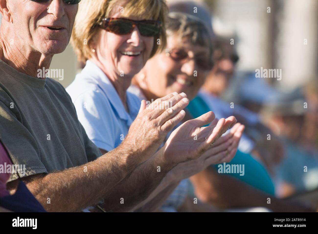 Group of people smiling and clapping together Stock Photo - Alamy