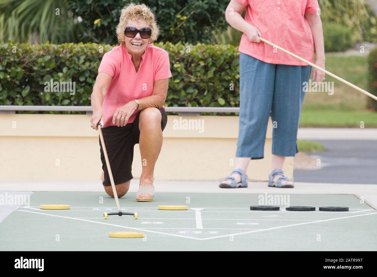 Two senior women playing shuffleboard Stock Photo - Alamy