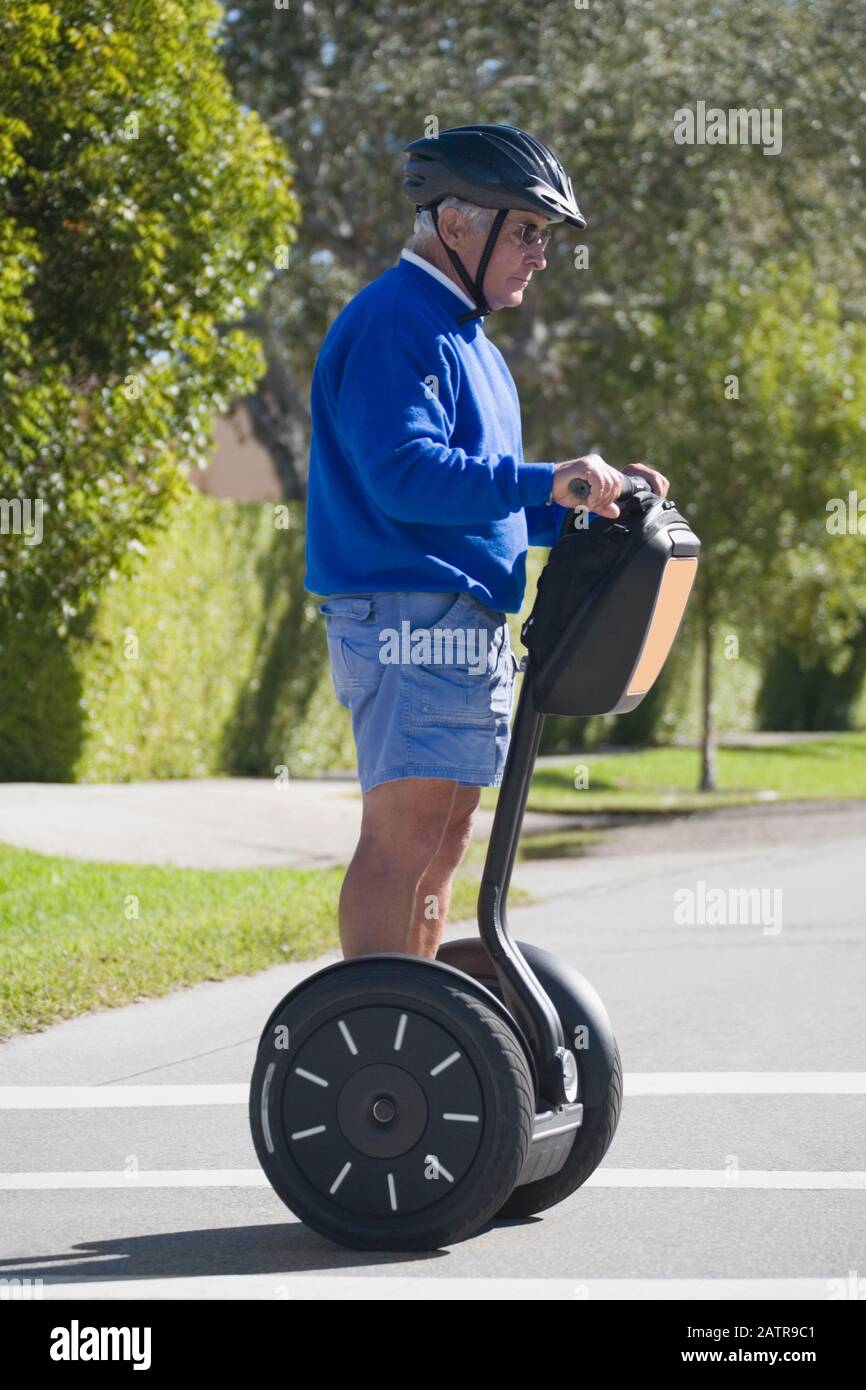 Side profile of a senior man riding a segway Stock Photo - Alamy