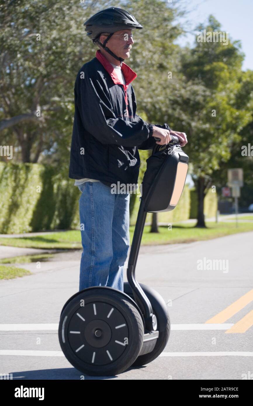 Side profile of a senior man riding a segway Stock Photo - Alamy