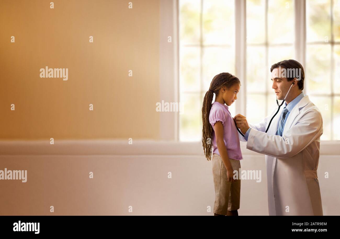 Young girl standing in front of doctor, having medical examination ...