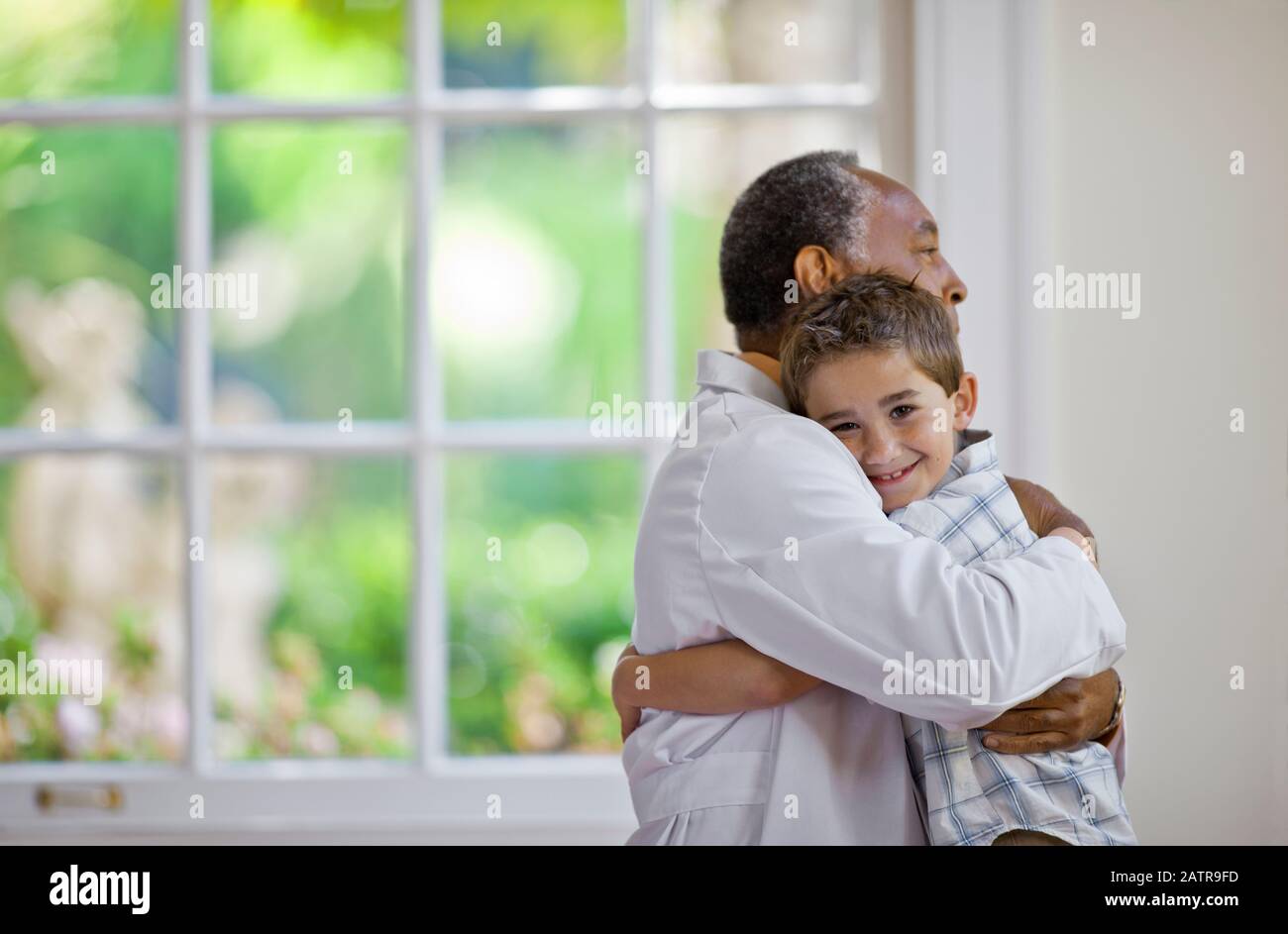 Smiling young boy hugging his doctor Stock Photo - Alamy
