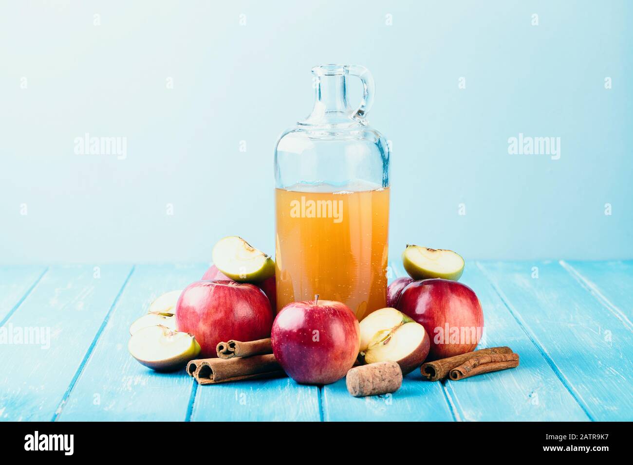 Fresh organic apple cider or apple juice with with cinnamon on the blue ...
