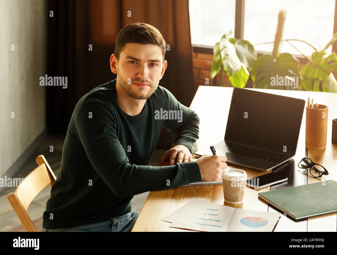 Positive Man At Laptop Computer Working Taking Notes Sitting Indoor ...