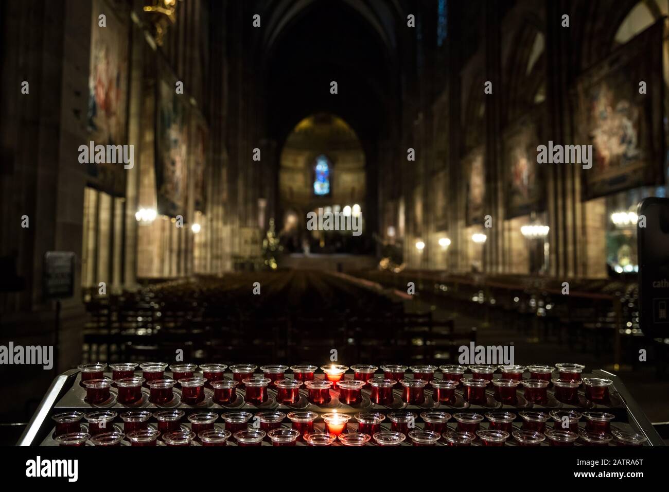 Lighting candles in a catholic temple . Candles are lit near the altar ...