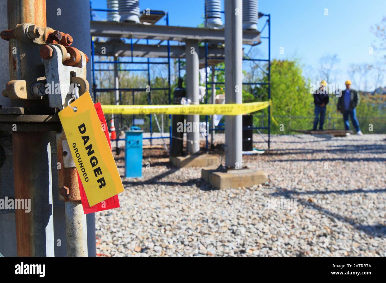 Two tradesmen stand in the distance with tags of 'danger' and 'grounded ...