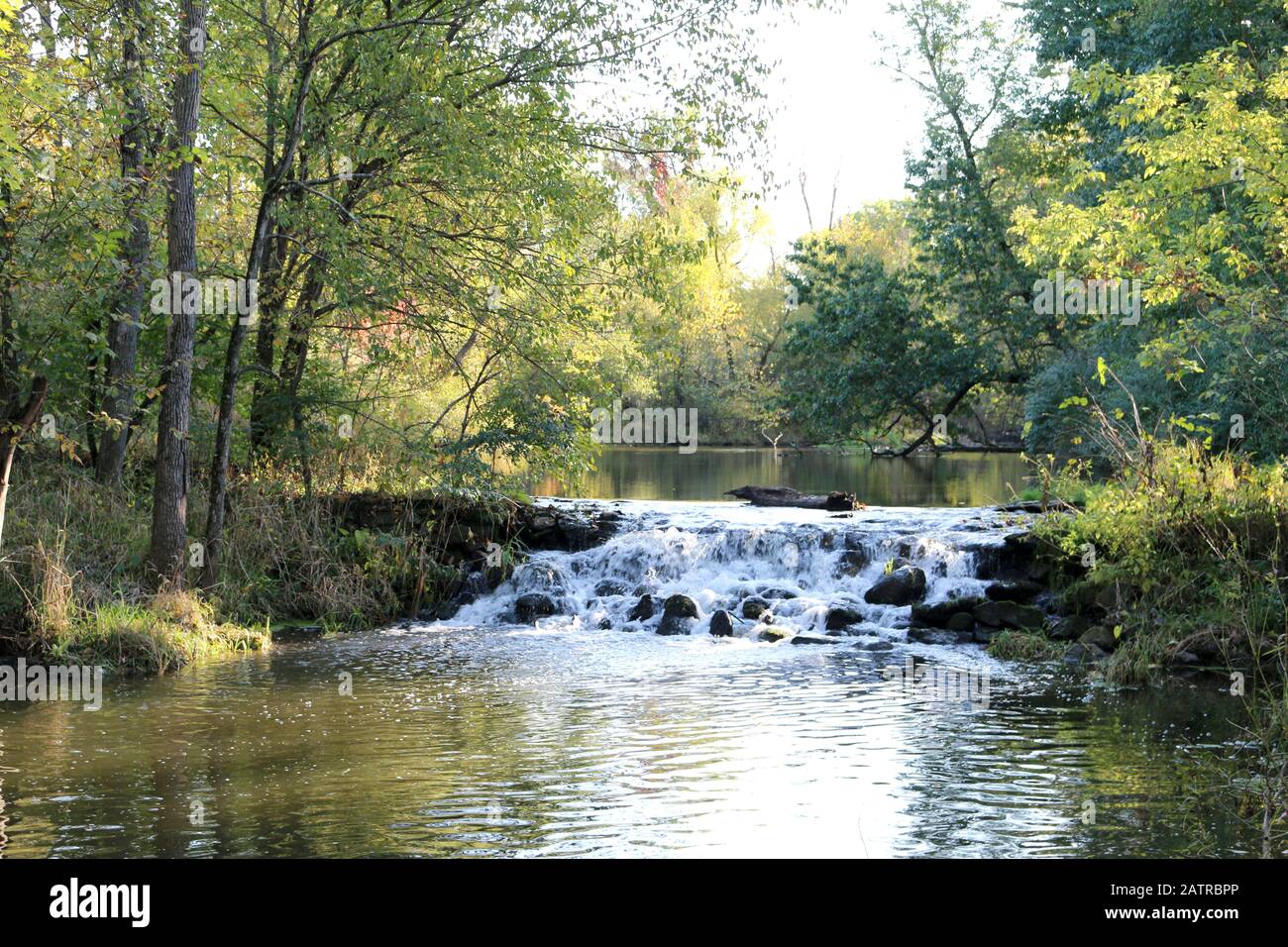 the bright sunny reflections of a brook waterfall Stock Photo - Alamy