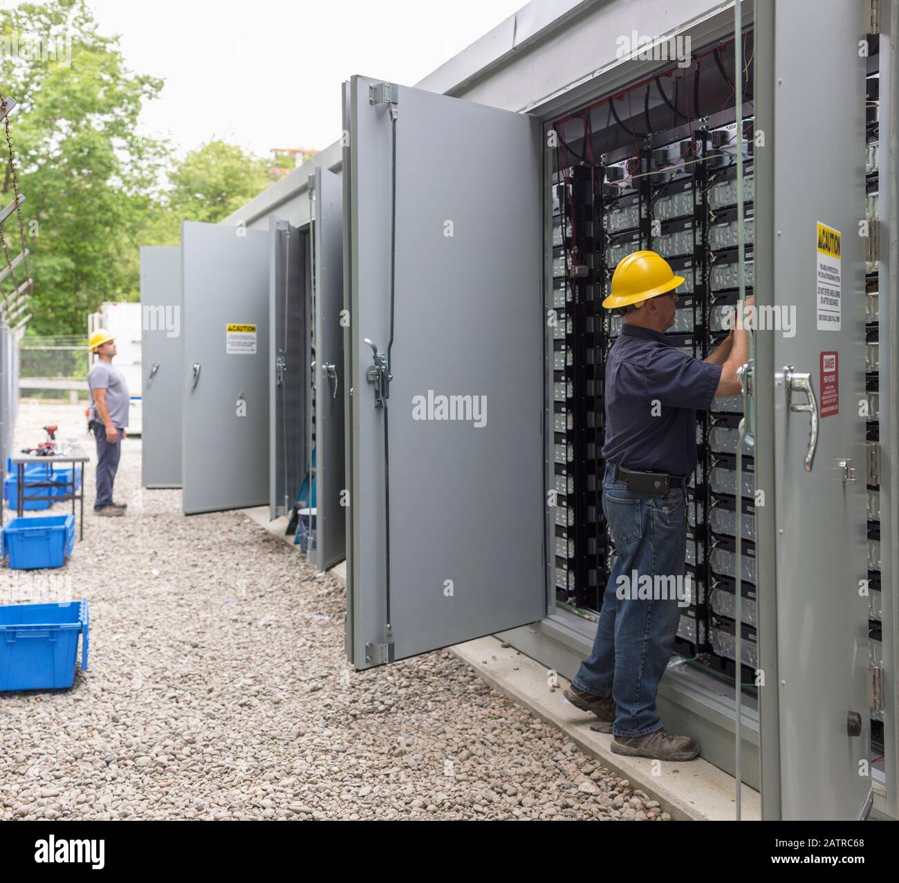 Engineers connecting energy storage batteries for back up power to an ...