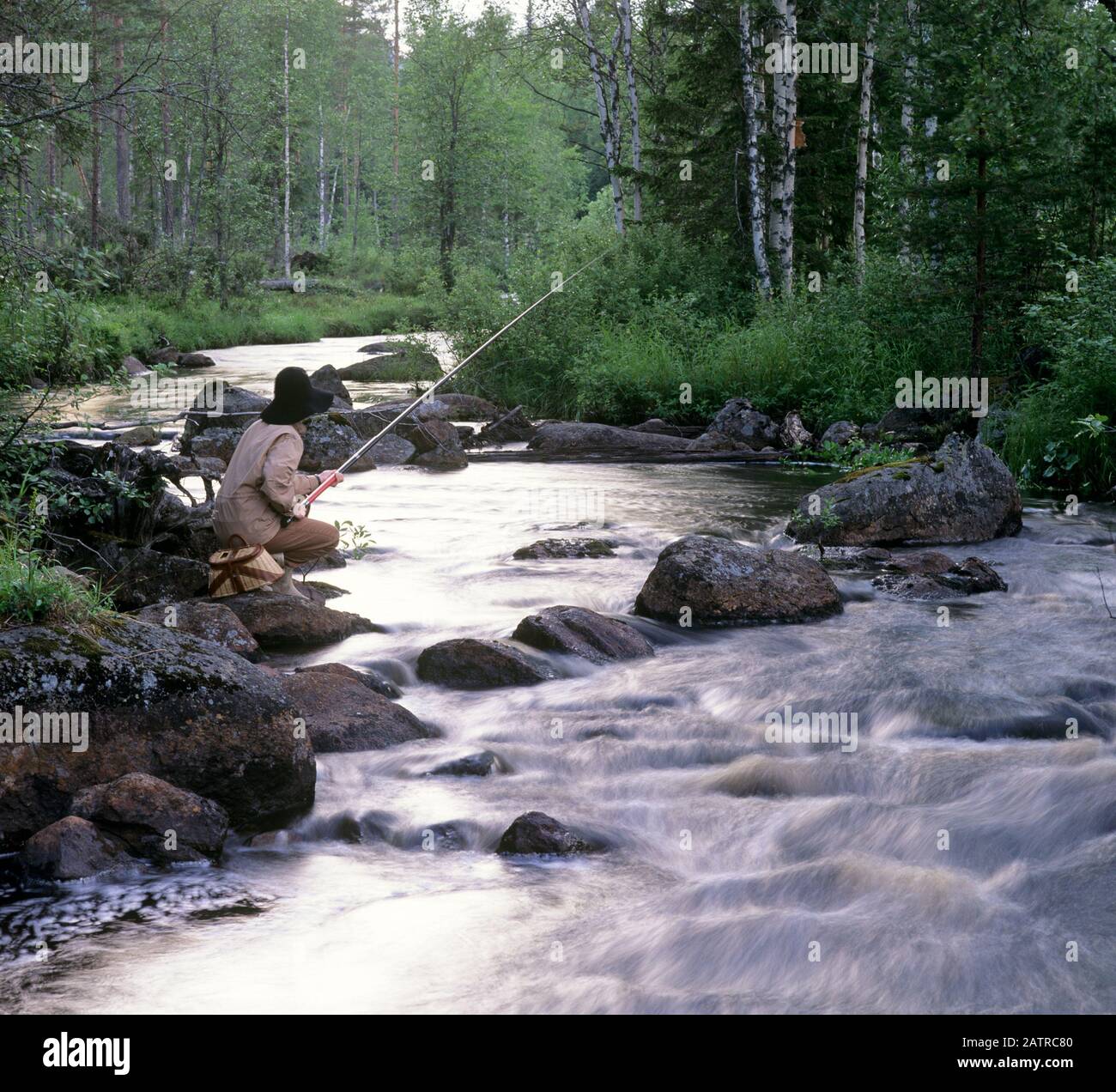 Woman fishing in a stream Stock Photo - Alamy