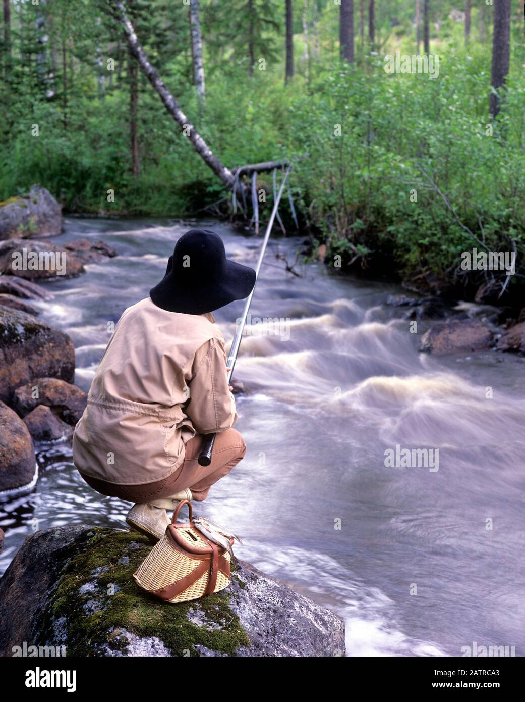Woman fishing in a stream Stock Photo - Alamy