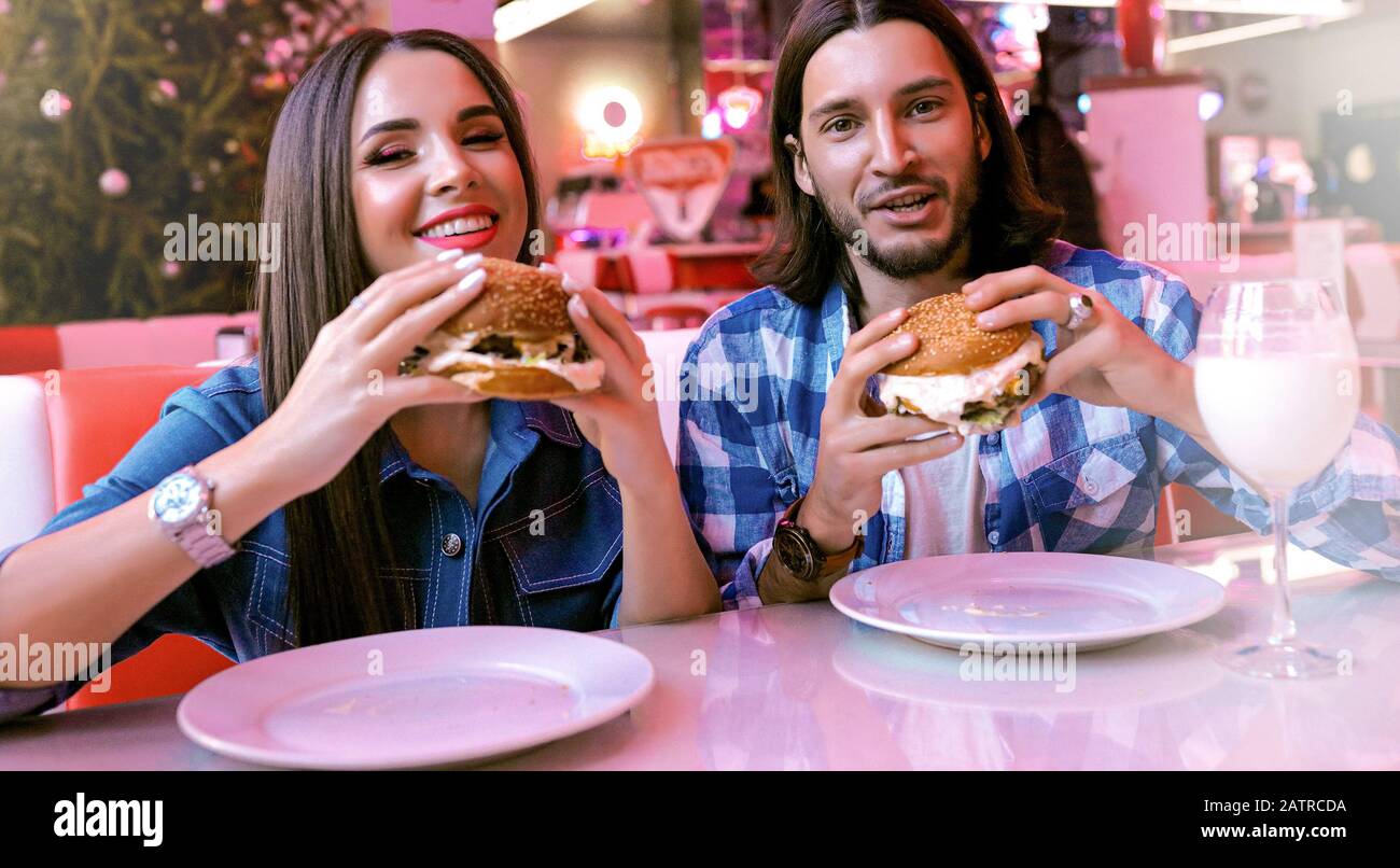 Fashionable people in the restaurant eating together some tasty meaty ...