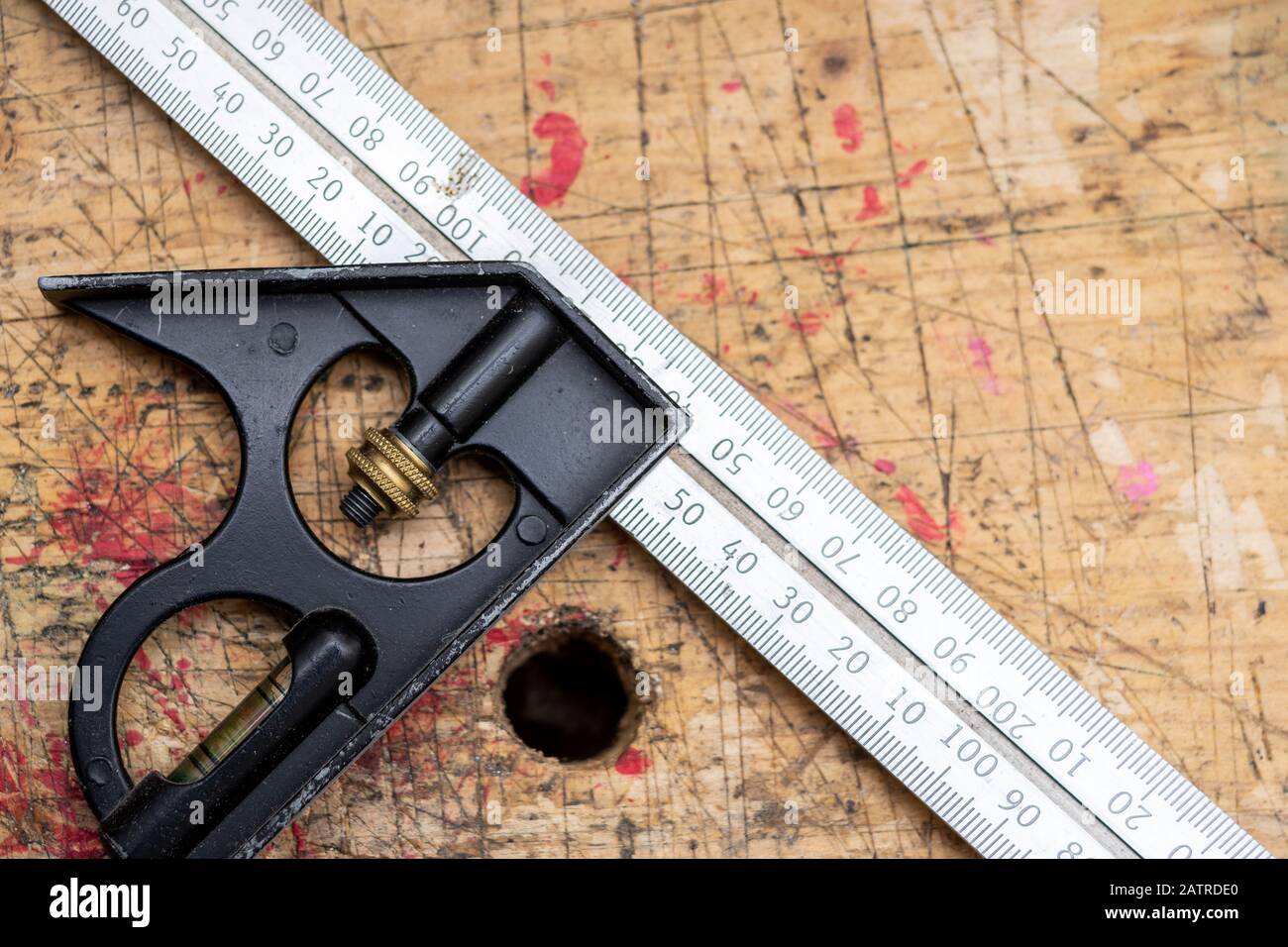 Carpenter engineer square, metal metering tool on wooden workbench ...