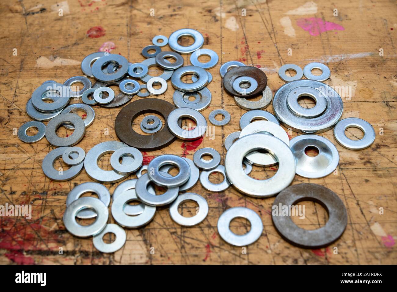 Assorted washers on wooden workbench stained grunge textured surface ...