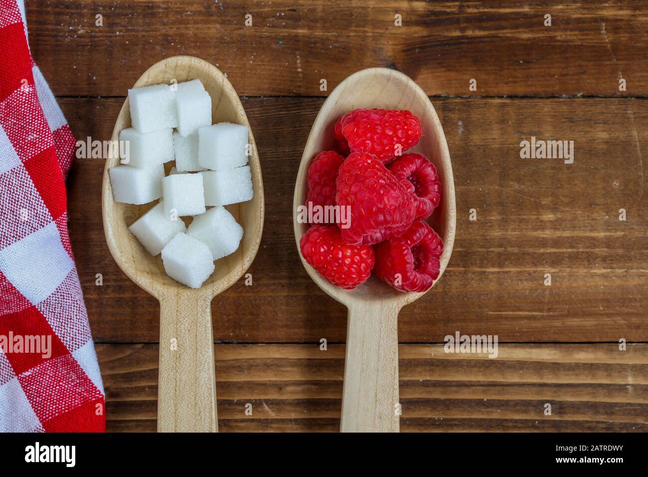 Healthy raspberries and unhealthy sugar in wooden spoons Stock Photo ...