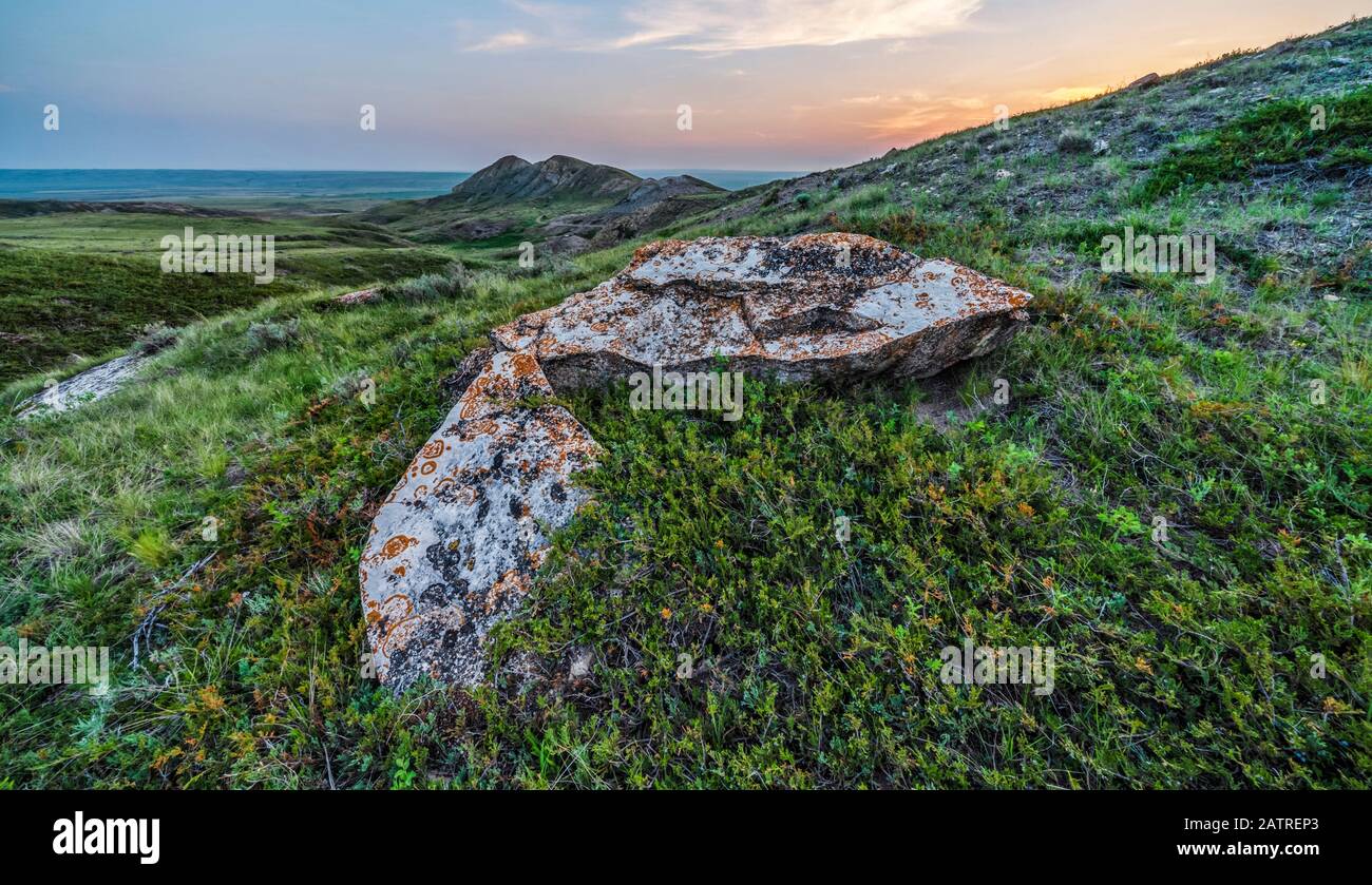 Sunset over the horizon with a rock in the foreround, Grasslands ...