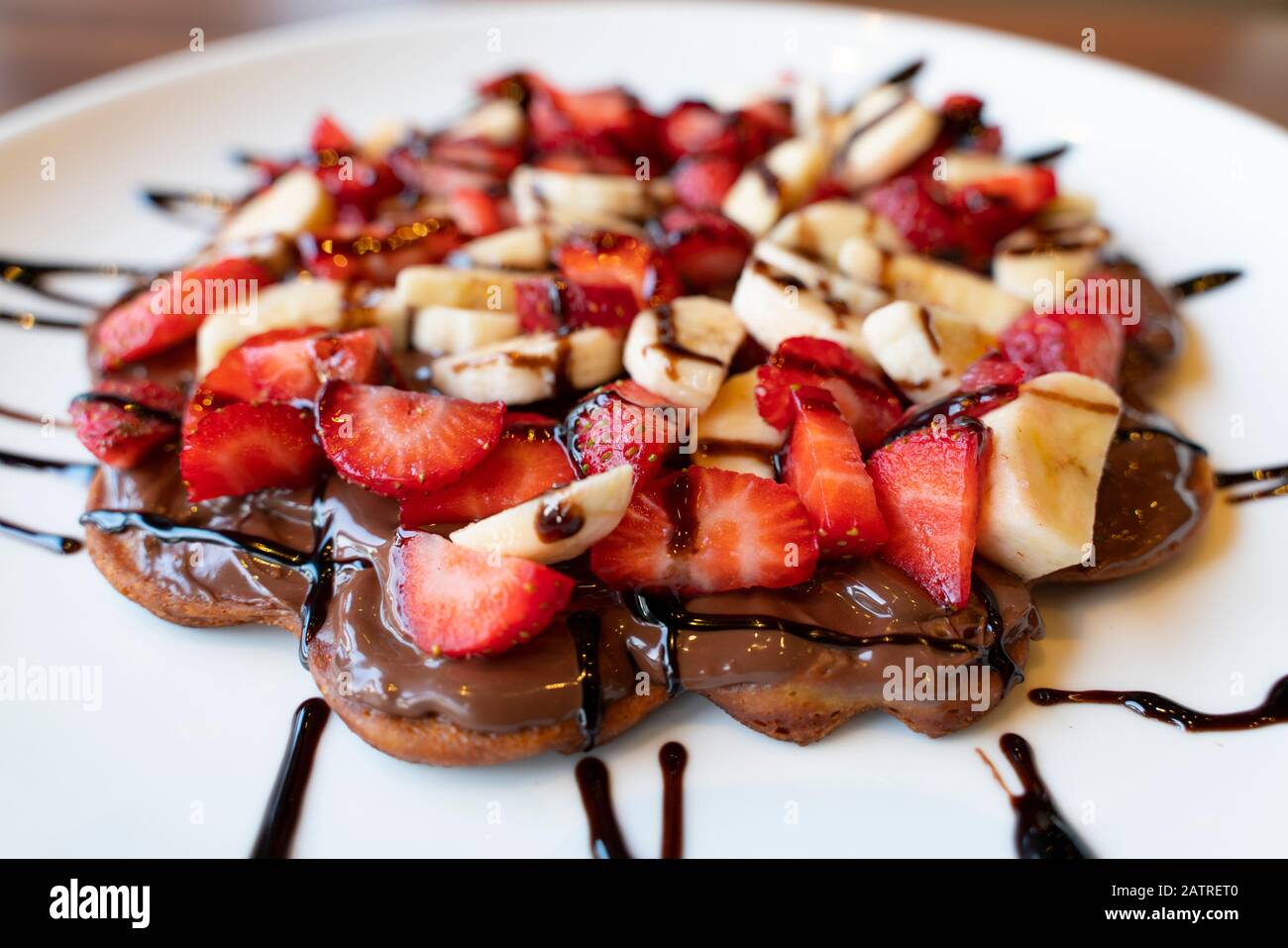 Traditional Belgian dessert - waffle with strawberry, banana and cream ...