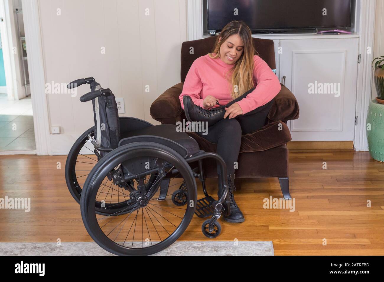 Woman with Spinal Cord Injury putting on shoes Stock Photo - Alamy
