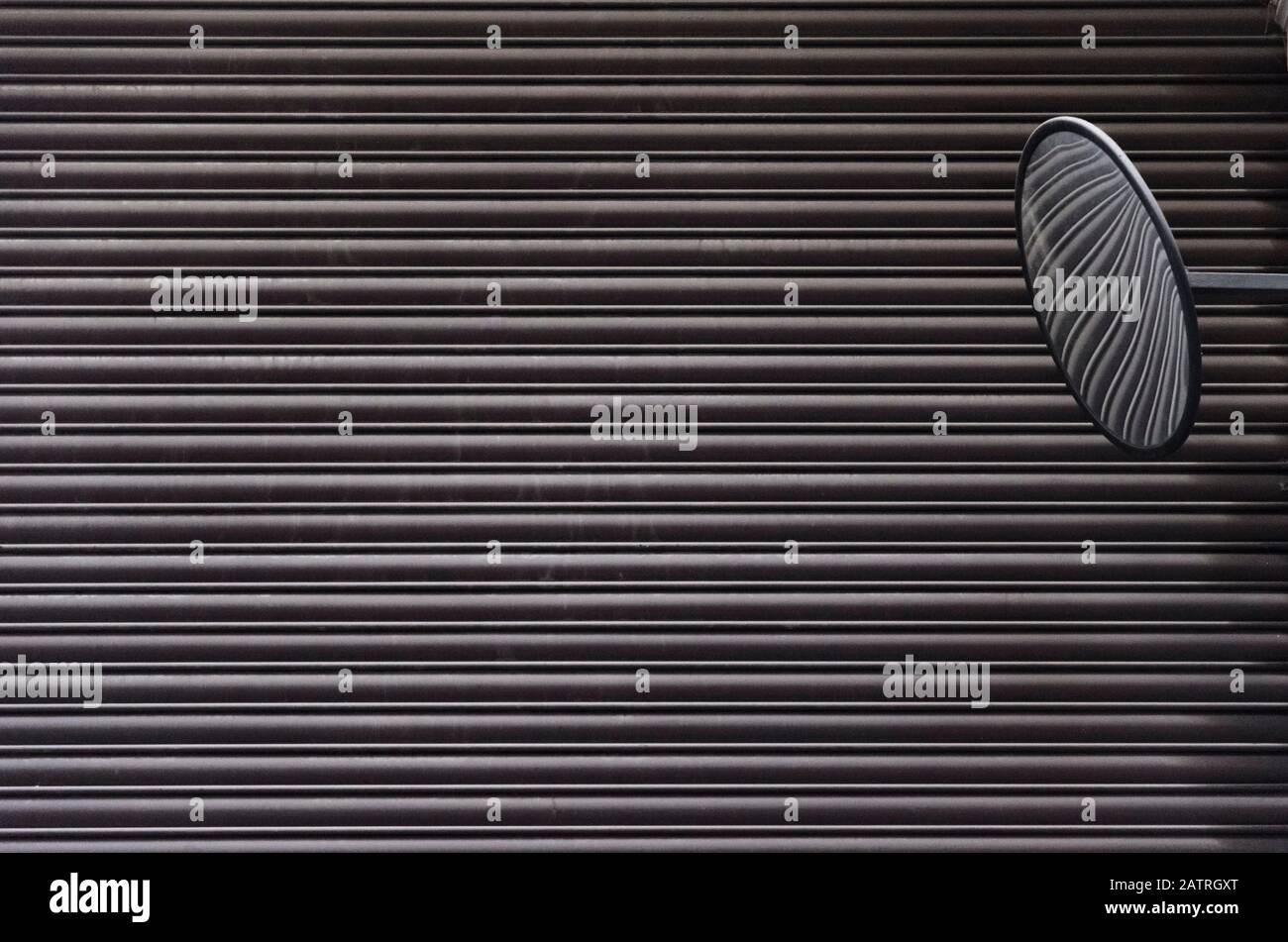 Gray metal rolling shutter door and safety mirror Stock Photo - Alamy
