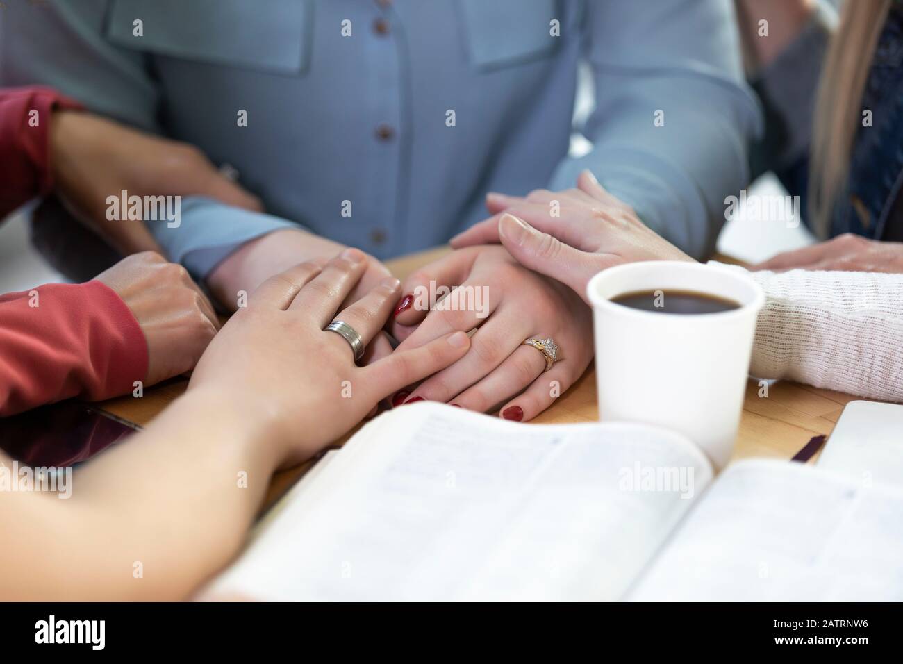 A group of women gathered together praying for one of the women after a ...