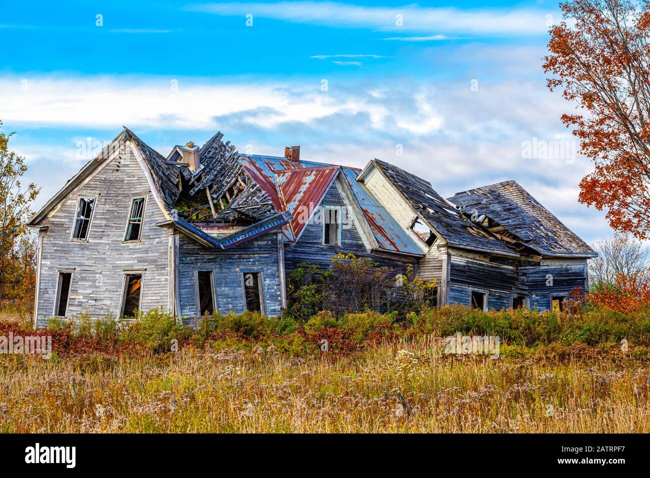 Dilapidated farmhouse in autumn with roof caving in; Scotstown, Quebec ...