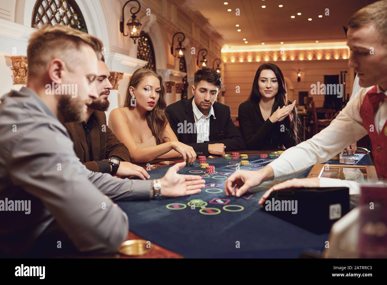 A group of wealthy young people gamble at a casino Stock Photo - Alamy