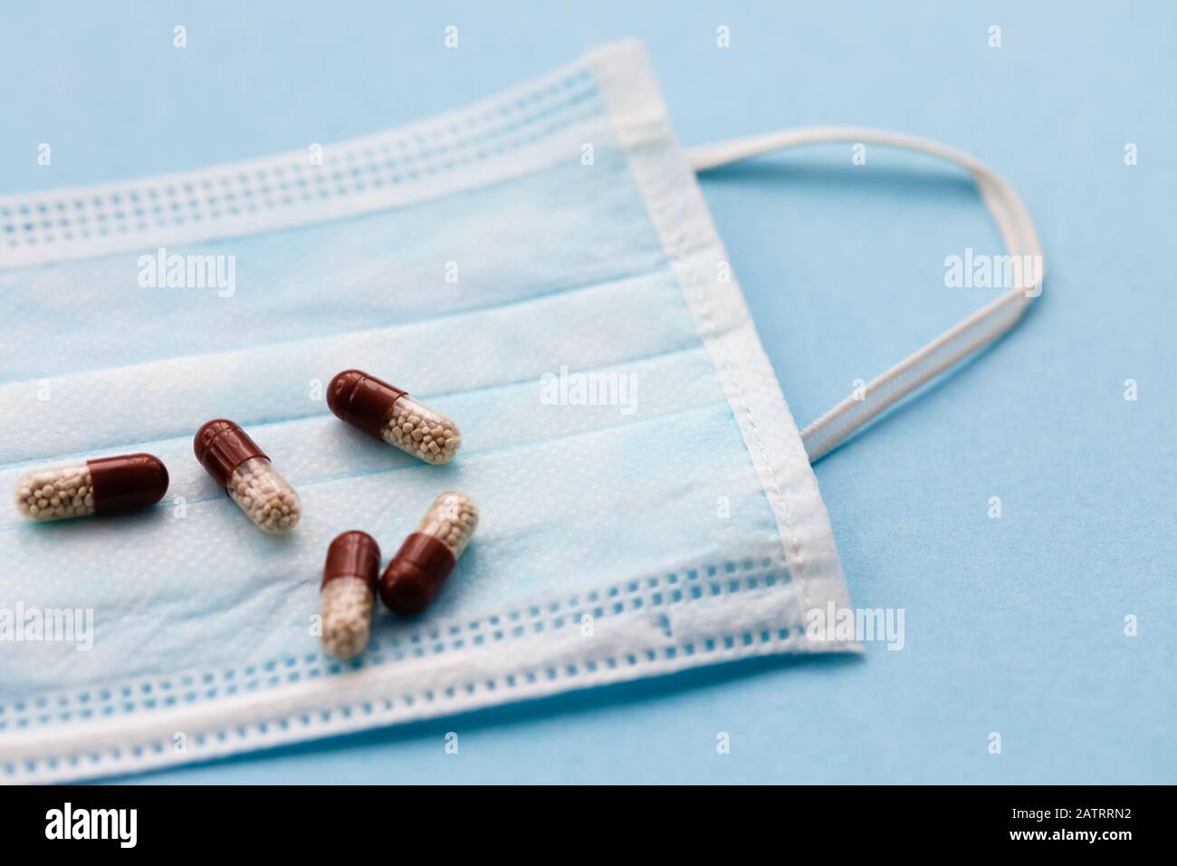 Tablets on blue background with surgical protective mask, medicine ...