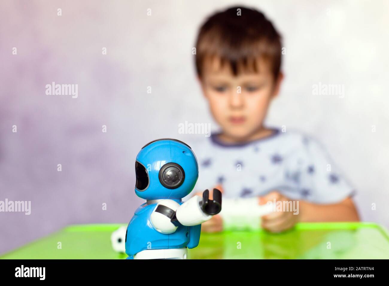 Little boy is playing with robot. Robot for children. Smart toy ...