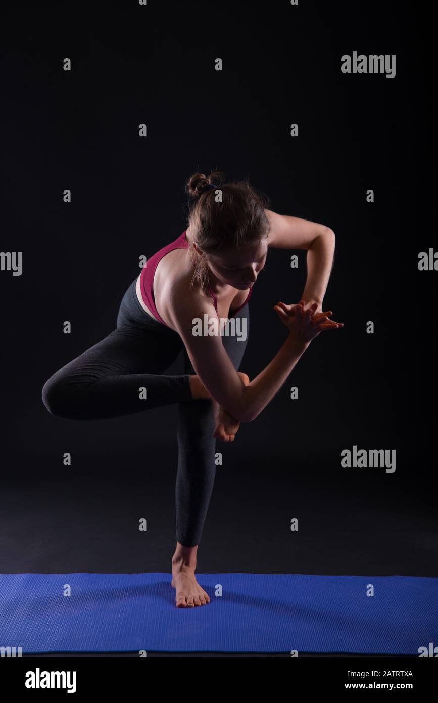 Young woman ispracticing yoga Revolved Chair.Parivṛtta Utkaṭāsana or ...