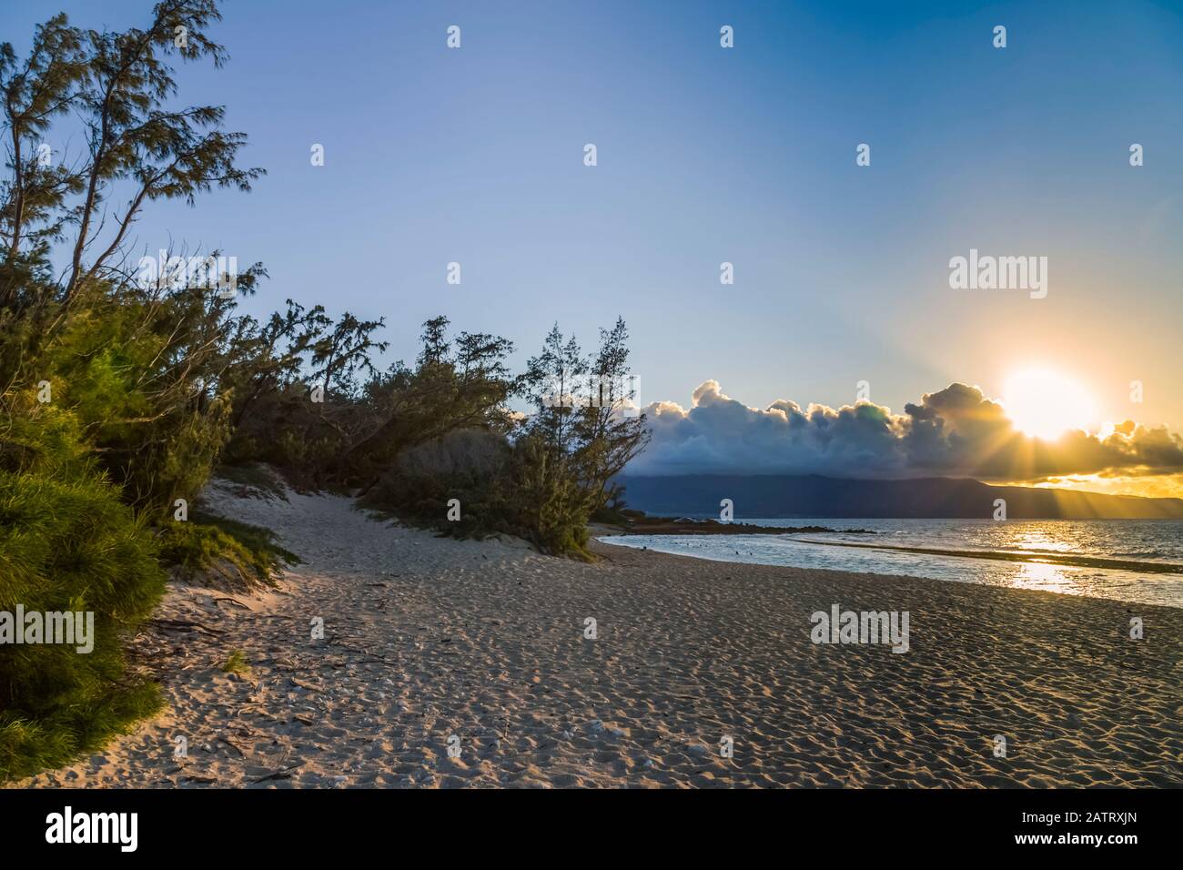 A beautiful, warm sunset on an empty beach in South Maui, Hawaii where ...