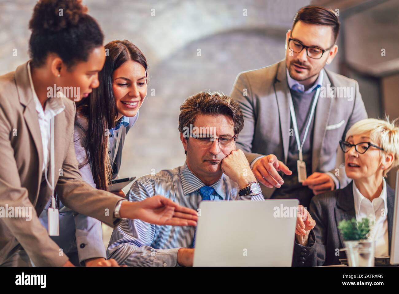 Smiling young manager helping senior worker with computer work in ...
