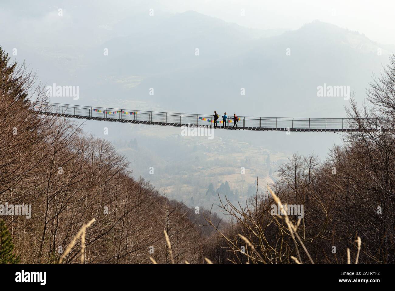 Hikers while crossing a Tibetan bridge located along a path on the ...
