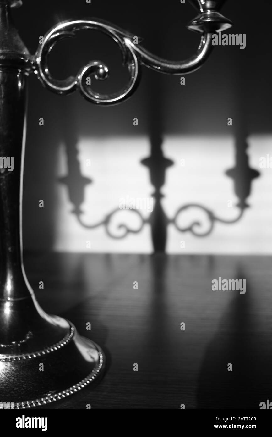 Closeup candlestick on three candles with shadow reflection on the wall ...