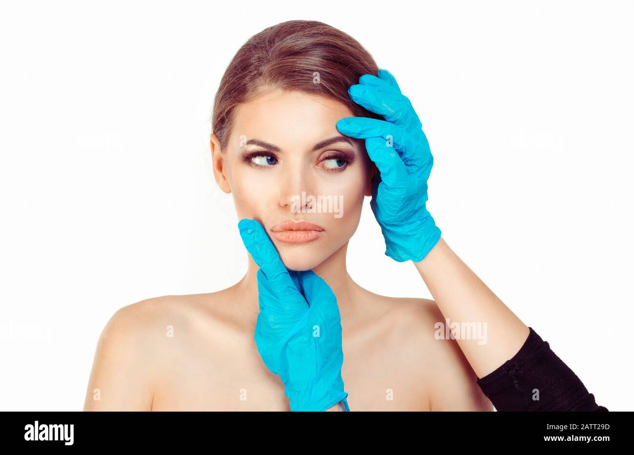 Skeptical woman looks to the surgeon hands while the doctor examines ...